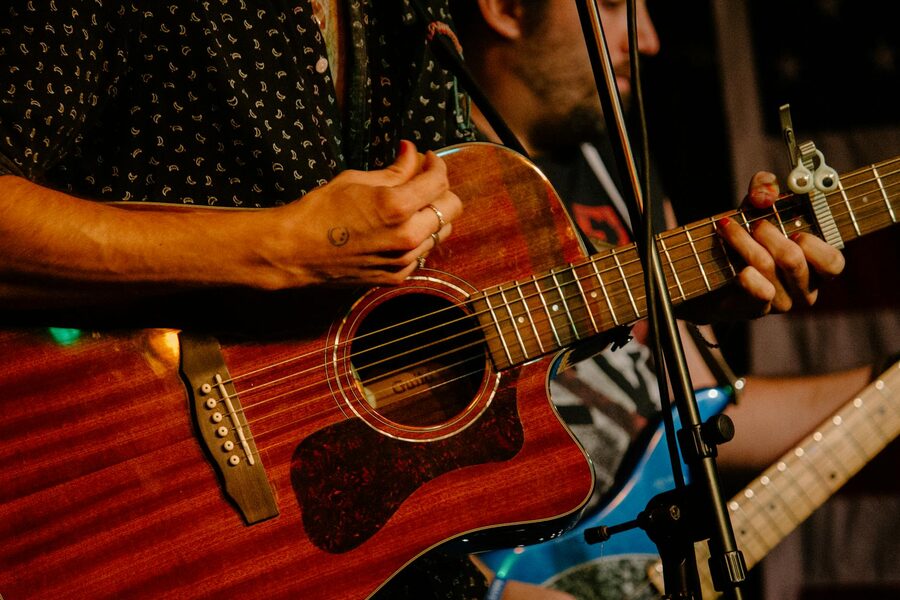 Hands playing acoustic guitar during a live performance