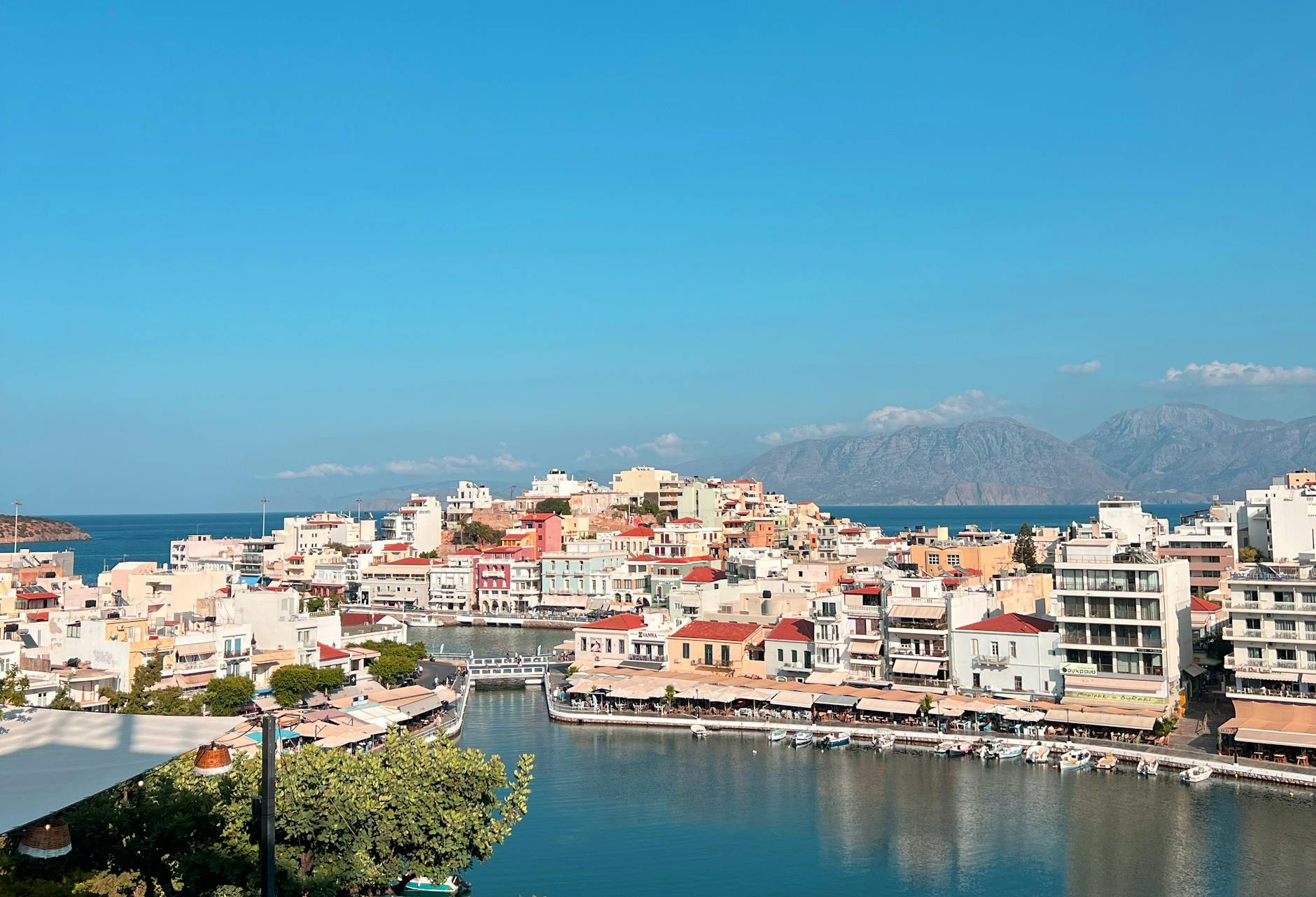 Colorful coastal city of Agios Nikolaos with mountain backdrop