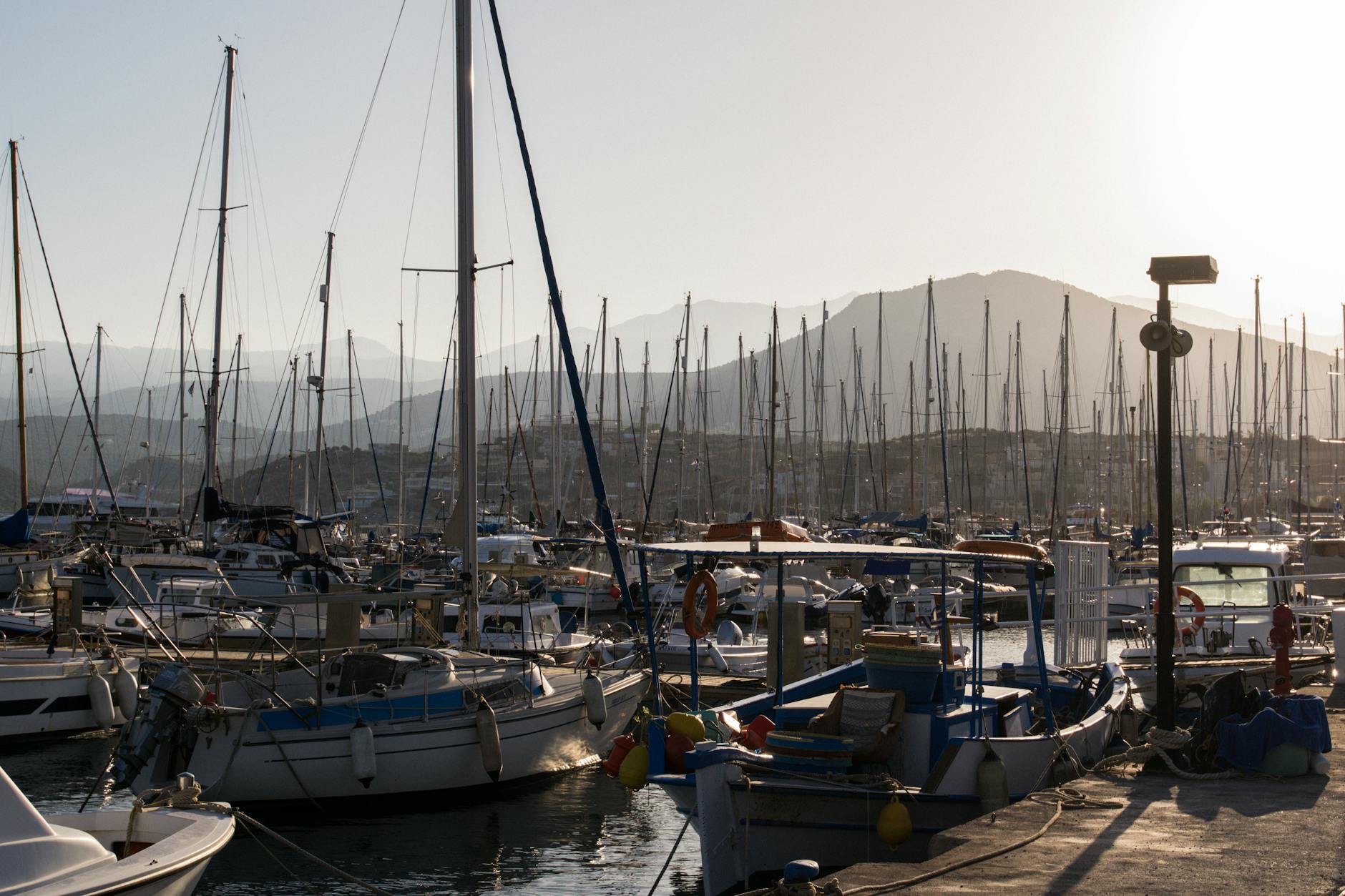 Sailboats moored at sunset in Agios Nikolaos harbor