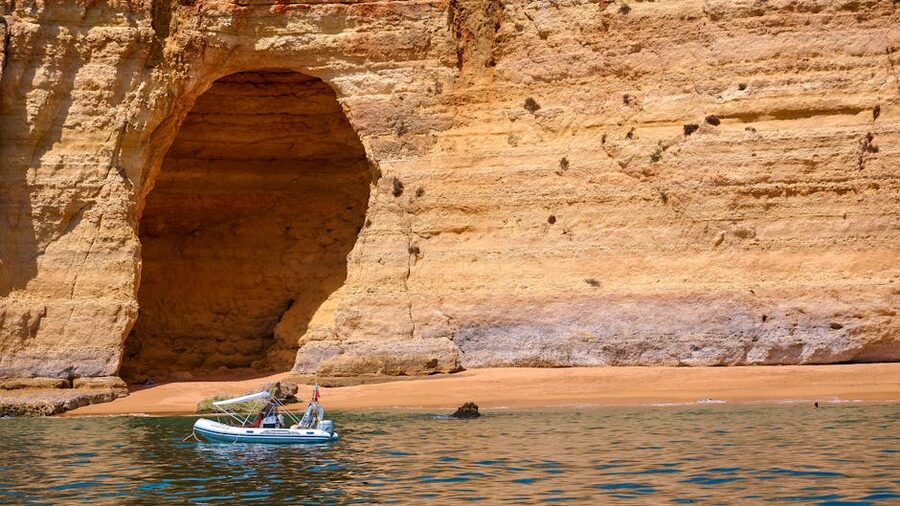 Boat cruising near the eroded cliffs of the Algarve coast in Portugal