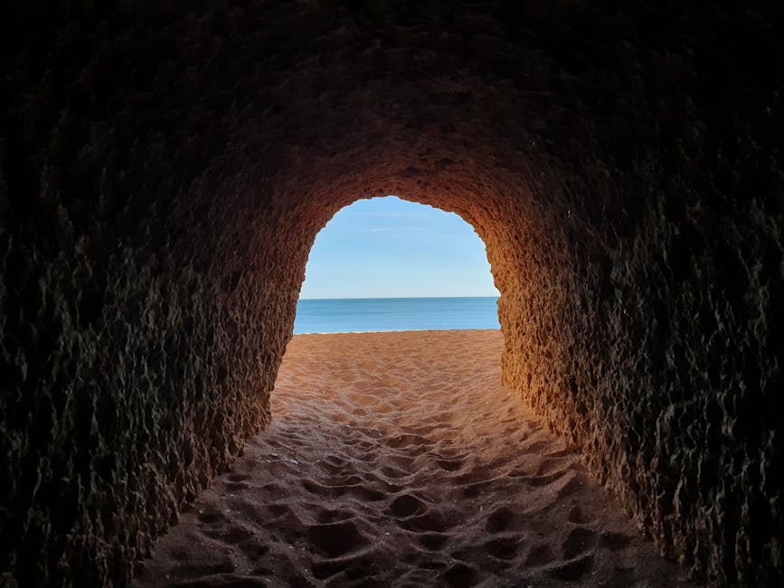 View from a cave tunnel leading to a small Algarve beach in Portugal