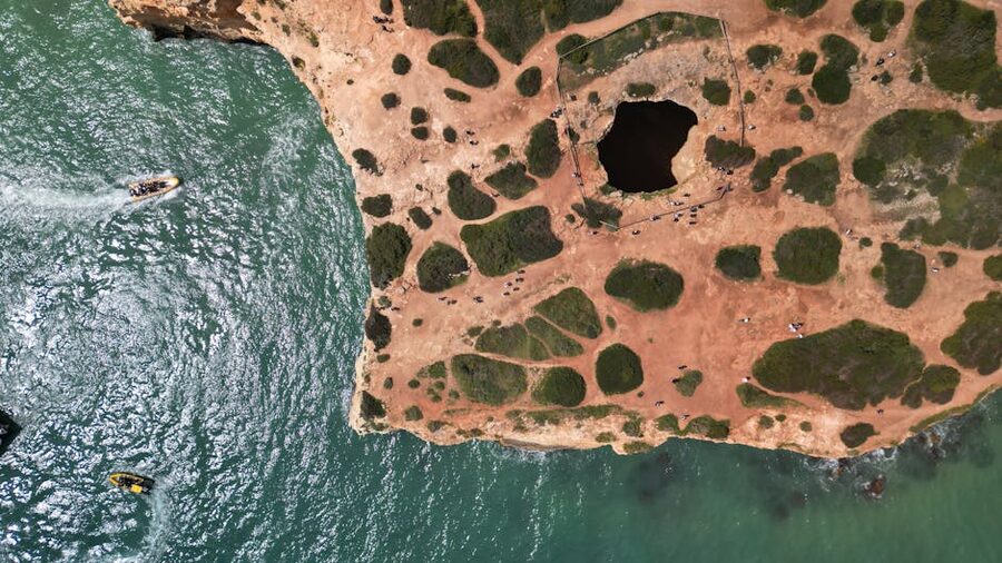 Aerial shot of the Algarve coastline with a natural cave and clear waters
