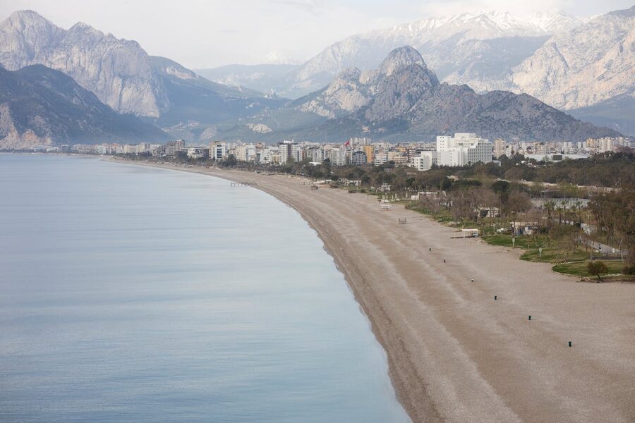 Antalya beach with Taurus Mountains in the background under blue sky