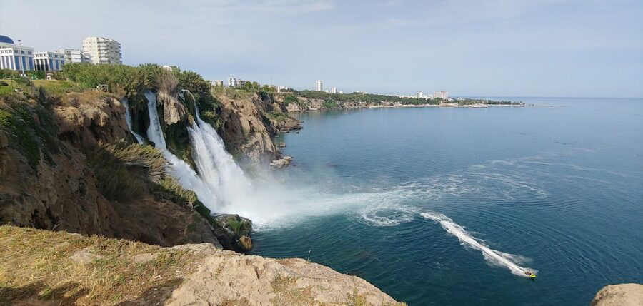 Duden Waterfall flowing over rocky cliff into turquoise Mediterranean water