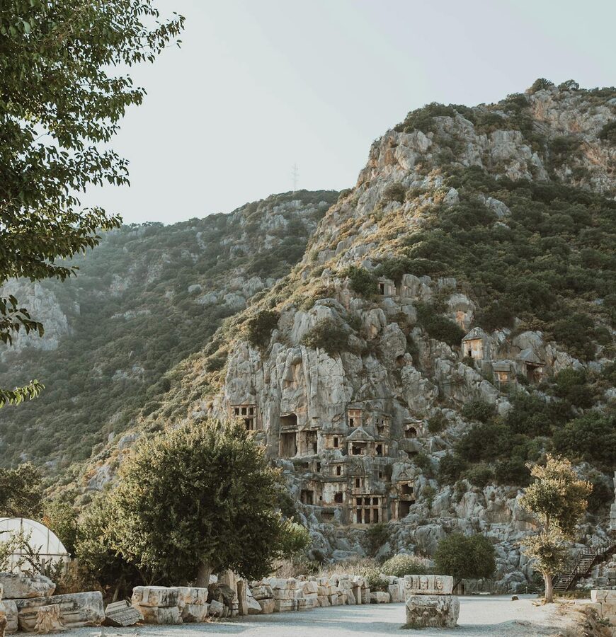 Lycian rock tombs set against a green hillside in Demre Antalya