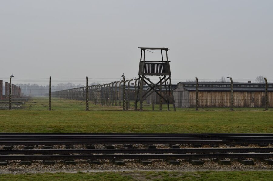 Auschwitz concentration camp with railway tracks and watchtower