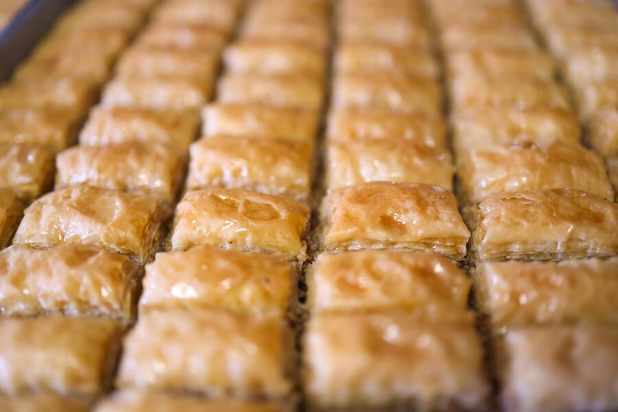 Freshly baked baklava pastries in rows at a Greek bakery