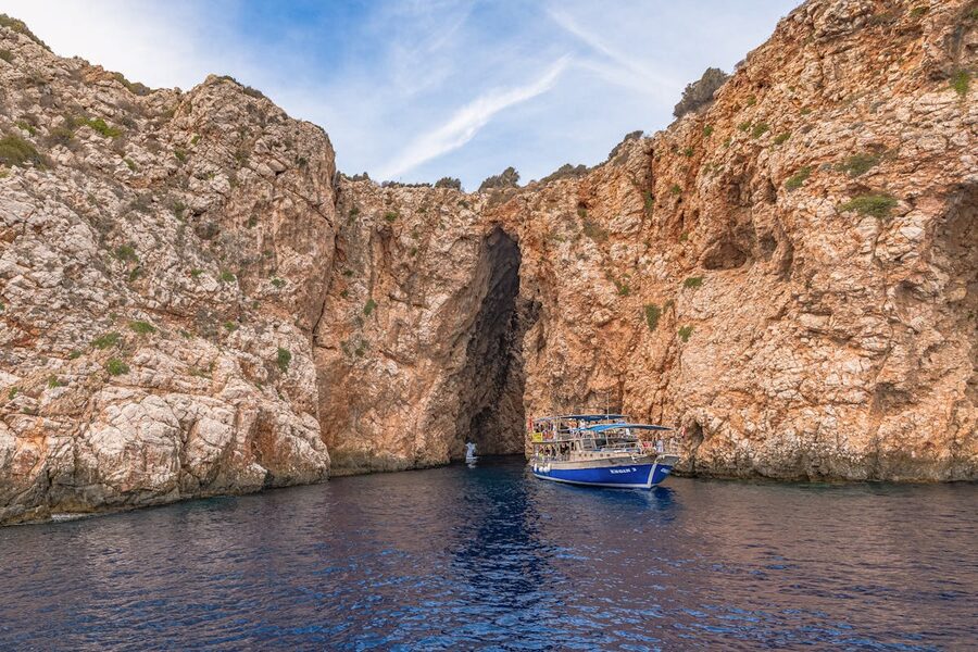 Speedboat approaching rocky cave along coast