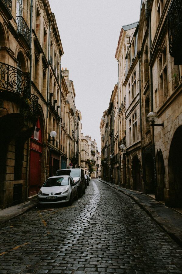 Cobblestone lane flanked by historic stone buildings in Bordeaux's old quarter