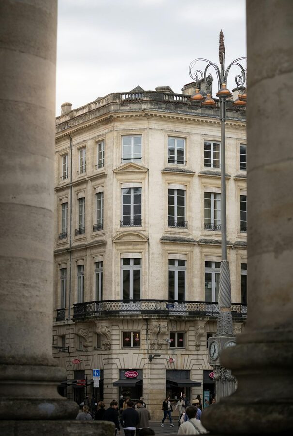 Historic Bordeaux building framed by stone columns showing classical French architecture