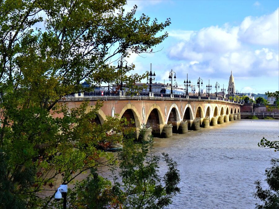 Pont de Pierre stone bridge spanning the Garonne River in Bordeaux on a sunny day