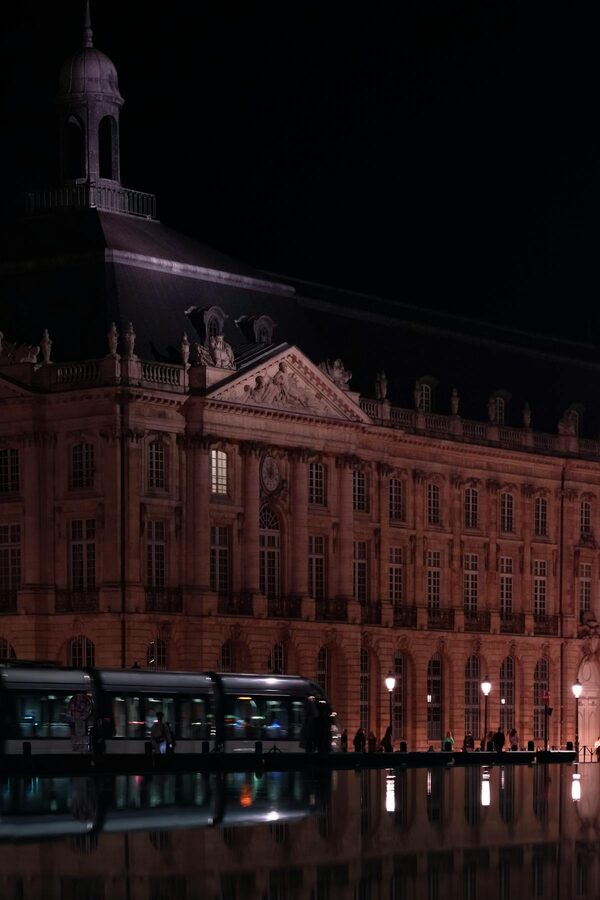 Place de la Bourse illuminated at night with reflections in the Miroir d'Eau