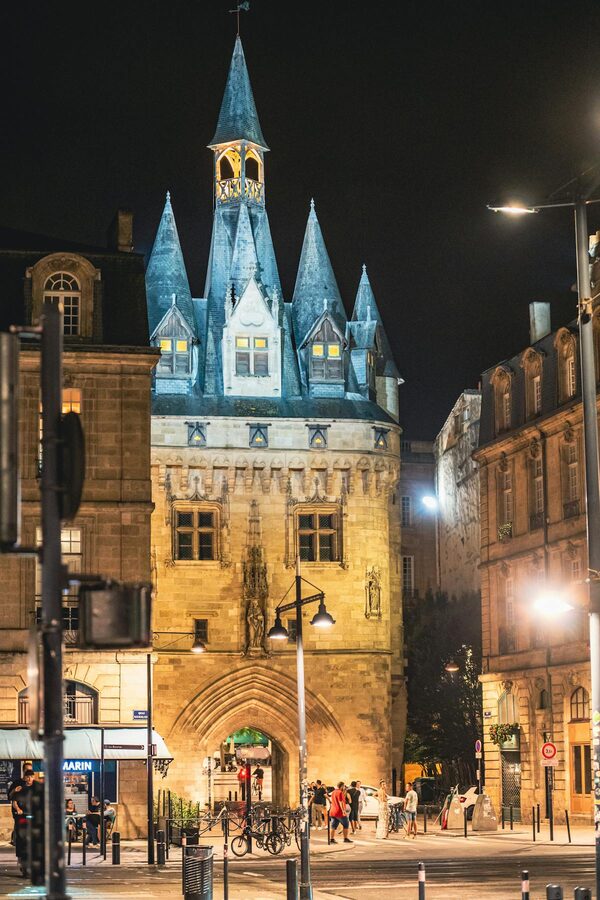 Porte Cailhau medieval gate illuminated at night in Bordeaux