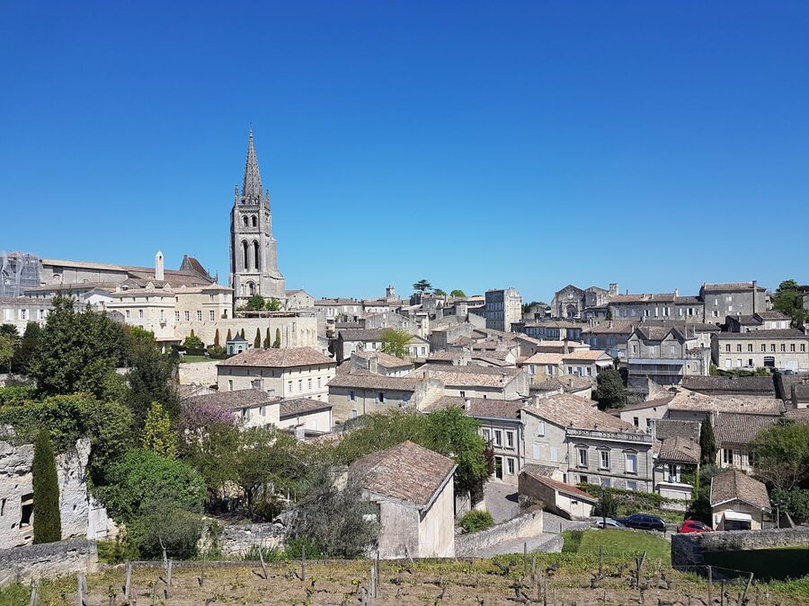 Medieval church tower rising above stone buildings in Saint-Émilion