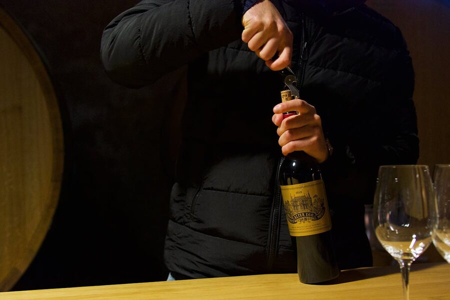 Sommelier uncorking a bottle of Bordeaux wine for a tasting
