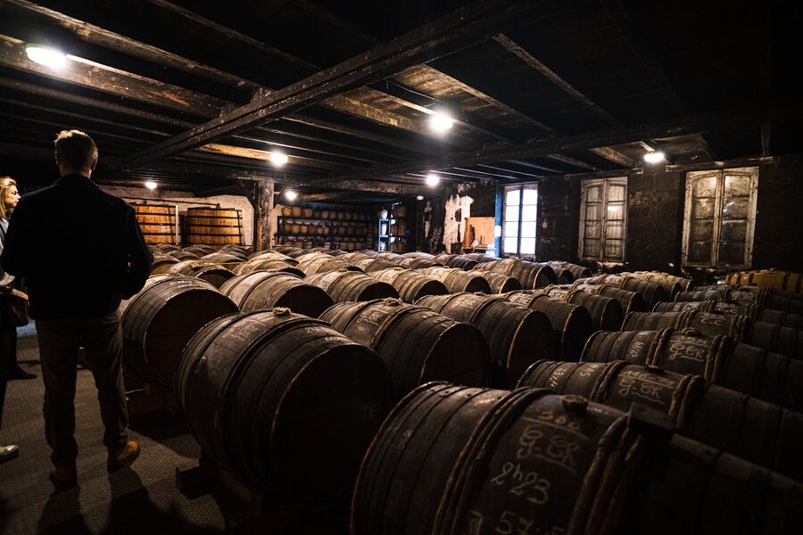 Wooden wine barrels aging in a dimly lit Bordeaux cellar
