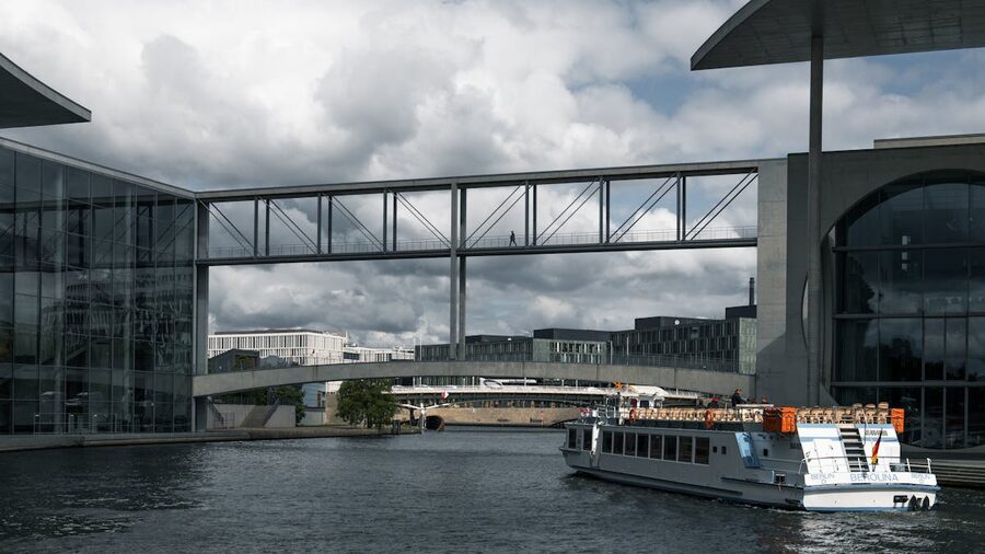 Ferry passing modern architecture along the Spree River in Berlin