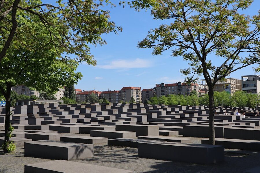 Holocaust Memorial in Berlin with concrete blocks under trees and clear sky