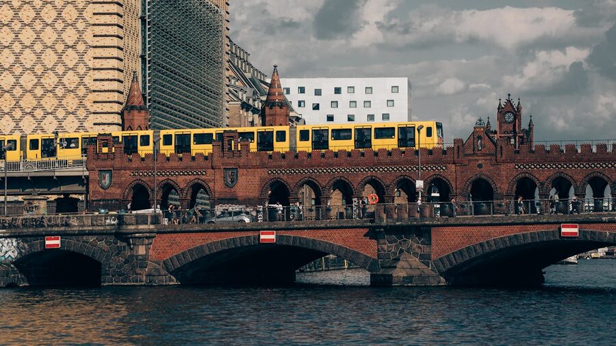 Yellow U-Bahn train crossing the Oberbaum Bridge in Berlin with cityscape