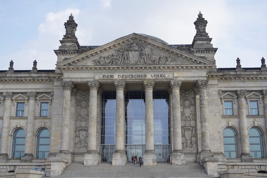 Front view of the Reichstag building in Berlin with classical columns and inscription