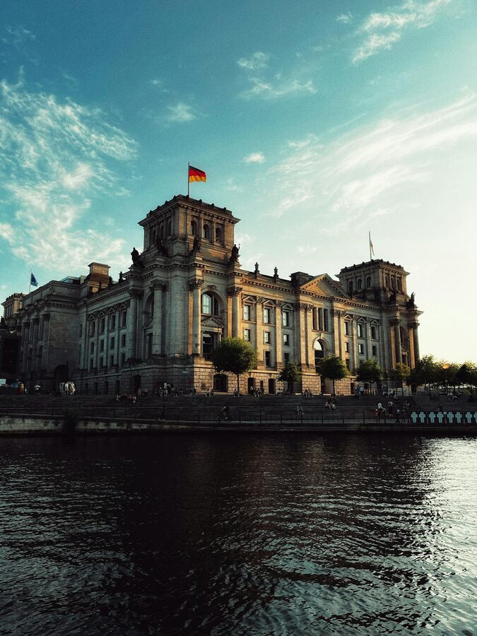 Reichstag Building reflected in the Spree River at golden hour in Berlin