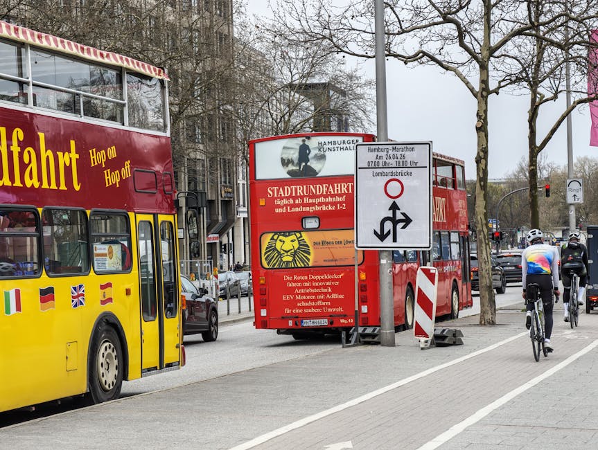 Bicyclists passing double-decker tour buses