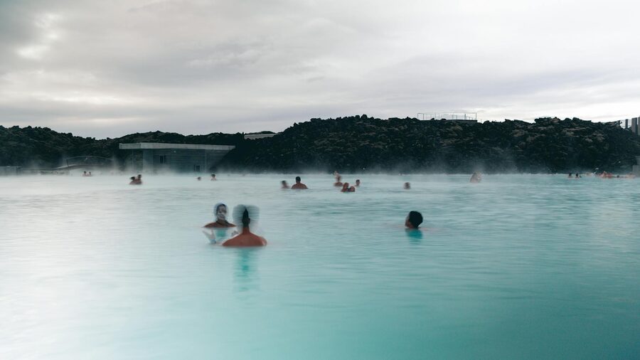 Visitors relaxing in the milky blue geothermal waters of the Blue Lagoon Iceland