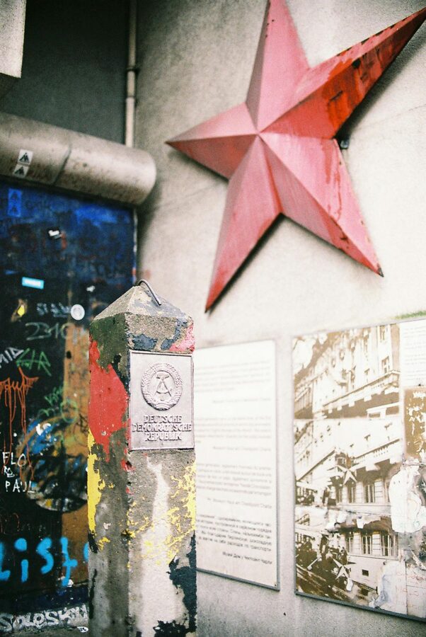 Colorful street art with a Soviet red star painted on remnants of the Berlin Wall