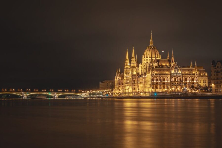 Hungarian Parliament Building illuminated at night by Danube