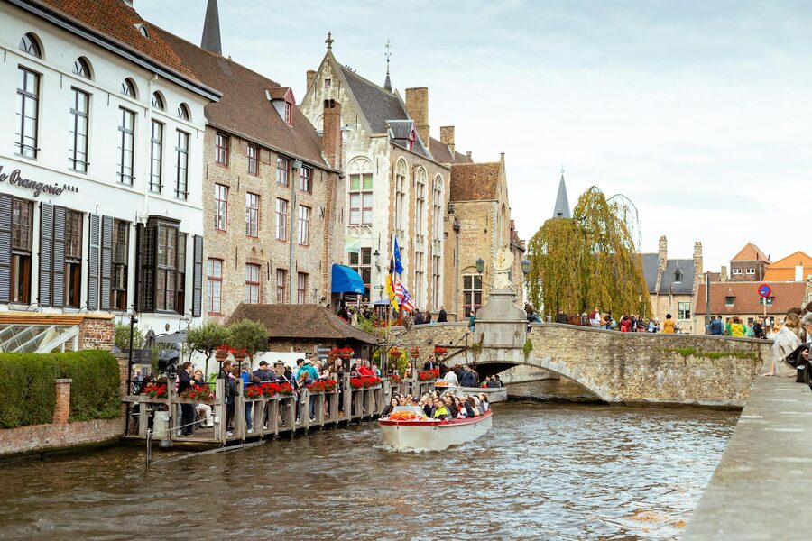 Bruges canal with historic buildings and tourist boat