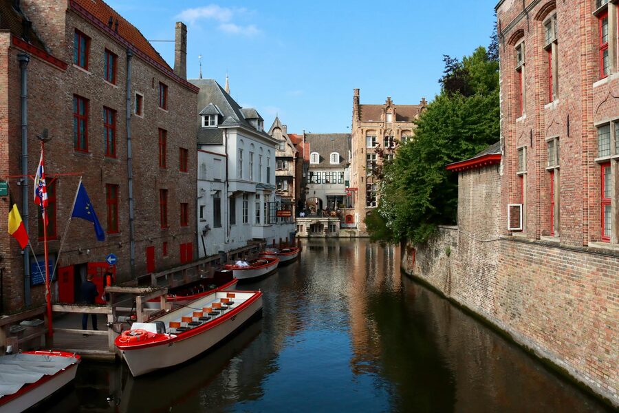 Canal in Bruges with moored boats and historic buildings