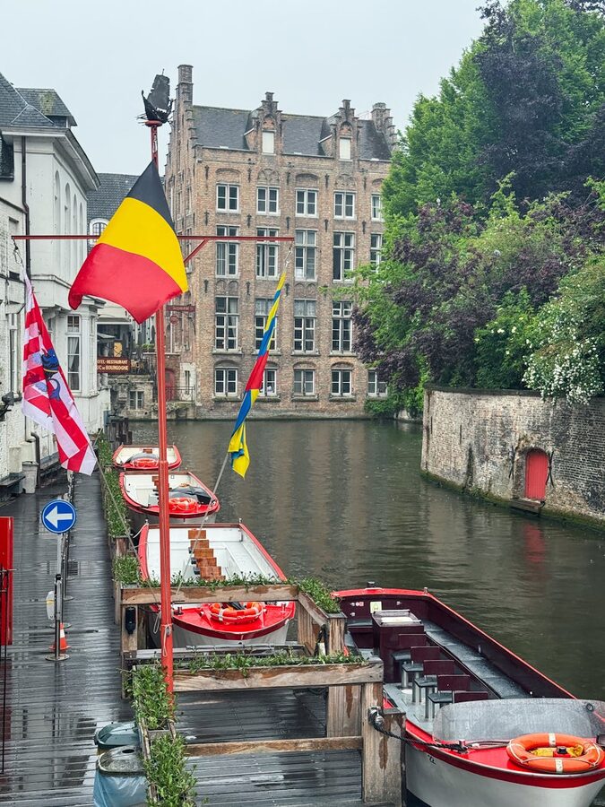Bruges canal with colourful flags and boats