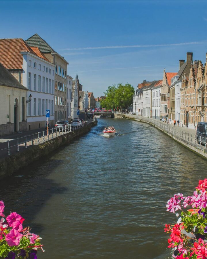 Bruges canal with flowers and historical buildings