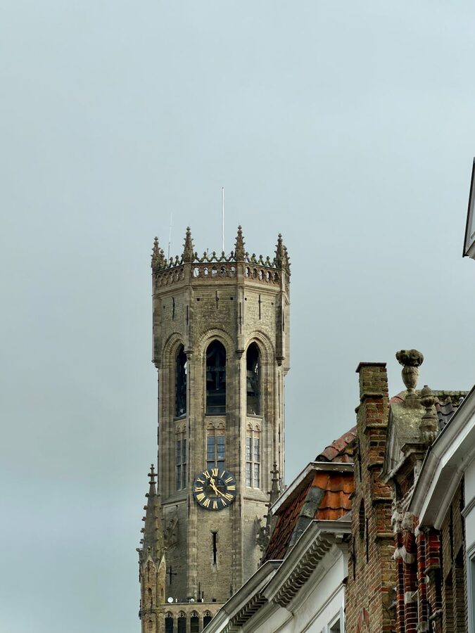 Bruges Belfry tower against cloudy sky