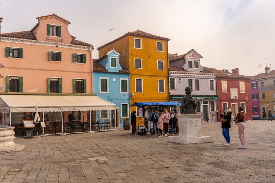 Tourists exploring Burano's colorful square