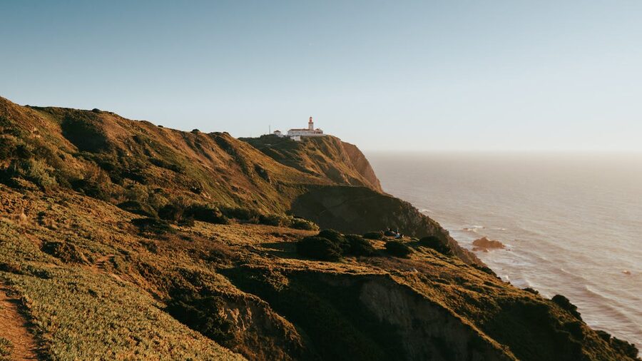 Cabo da Roca lighthouse on rugged cliff overlooking Atlantic Ocean in Portugal