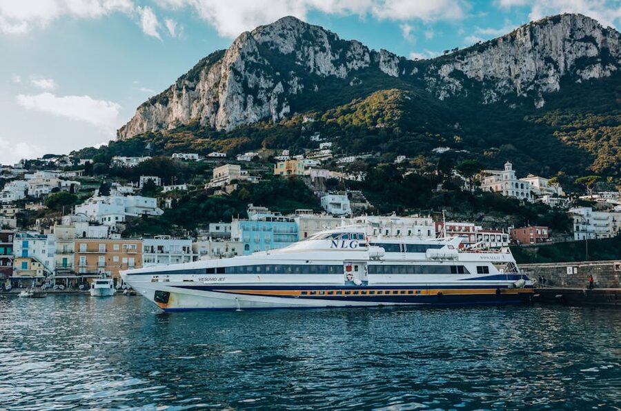 Ferry docked at Capri Island harbor with mountain