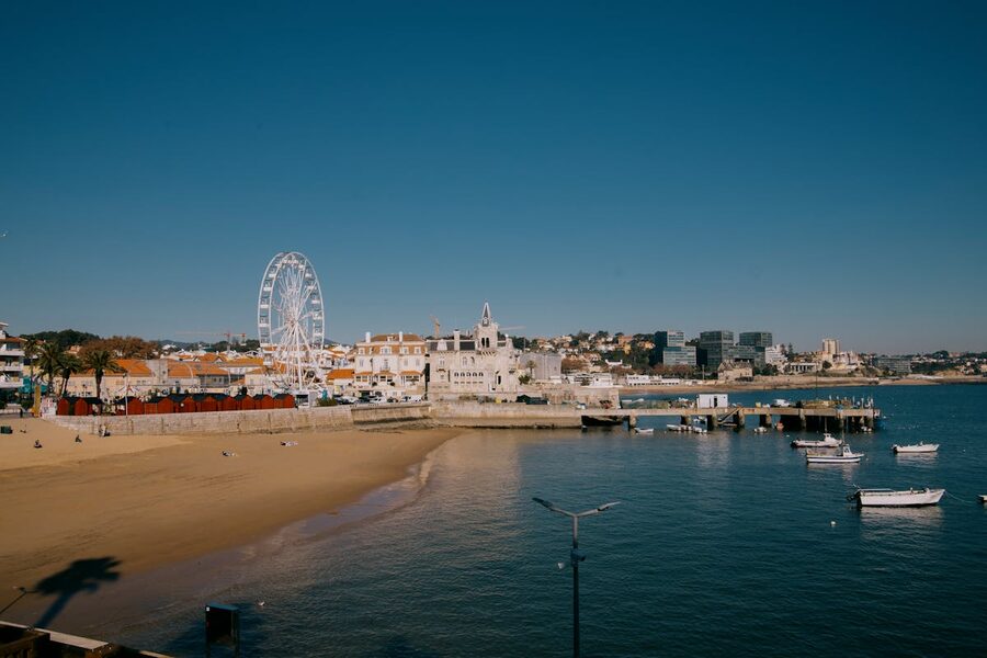 Aerial view of Cascais town beach and harbor with Ferris wheel in Portugal
