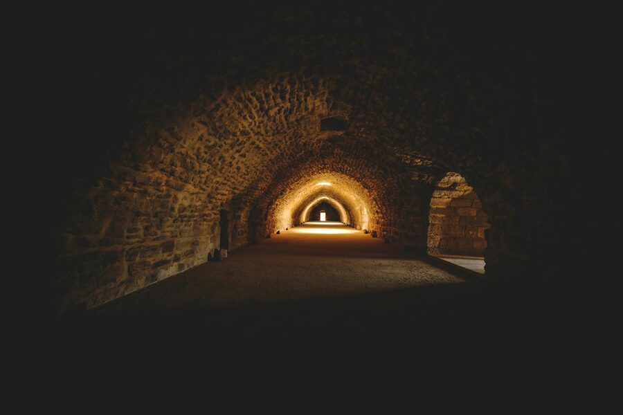 Gothic tunnel with stone architecture and warm lighting