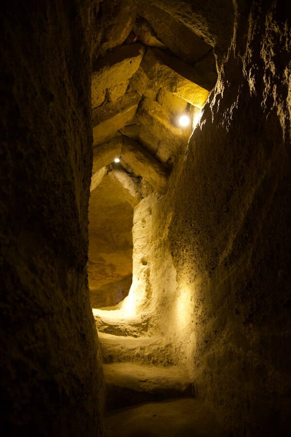 Ancient illuminated stone corridor underground