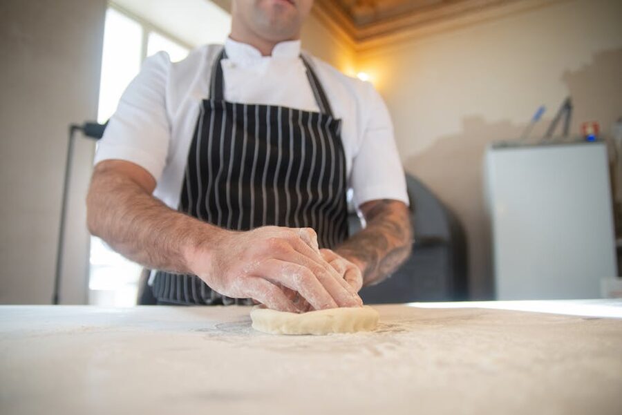 Chef kneading pizza dough