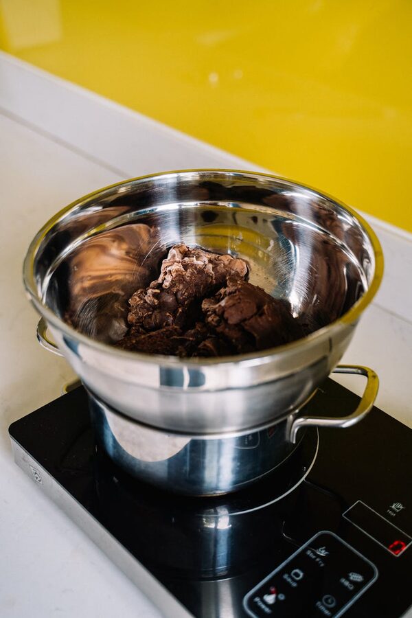 Stainless steel bowl with chocolate melting on stove