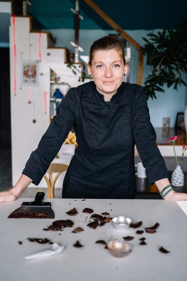 Chef with chocolate pieces and tools on counter