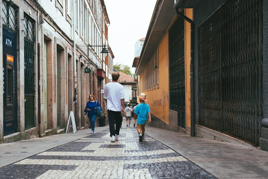 People walking through a cobblestone alley in Porto