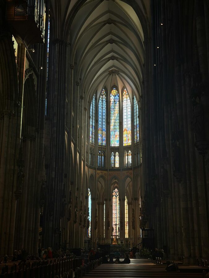 Gothic interior of Cologne Cathedral with stained glass and stone arches