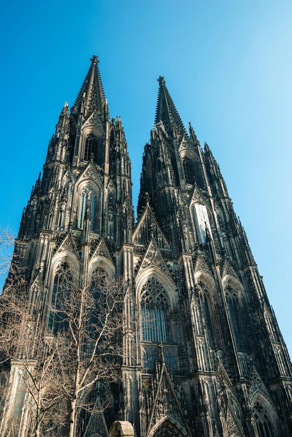 Gothic spires of Cologne Cathedral reaching into clear blue sky