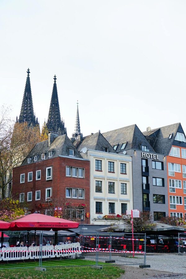 Colorful historic buildings in Cologne with cathedral spires in background