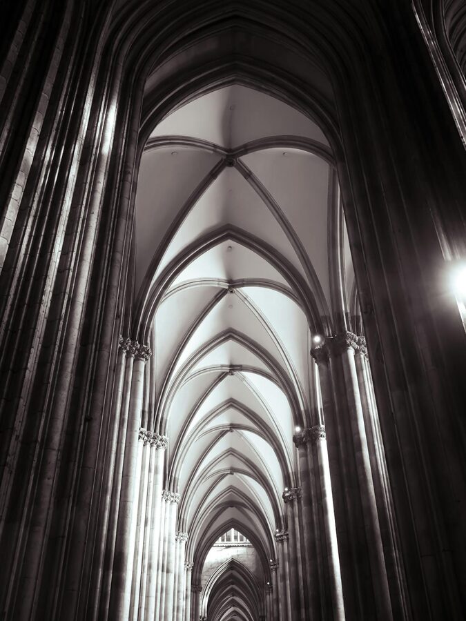Gothic arches and vaulted ceiling inside Cologne Cathedral in dramatic light