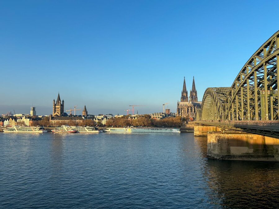 Cologne Cathedral and Hohenzollern Bridge over Rhine River in evening light