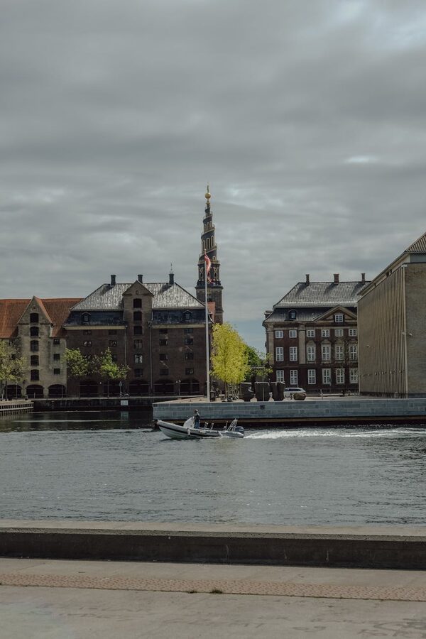 Tour boat passing through a Copenhagen canal with historic architecture